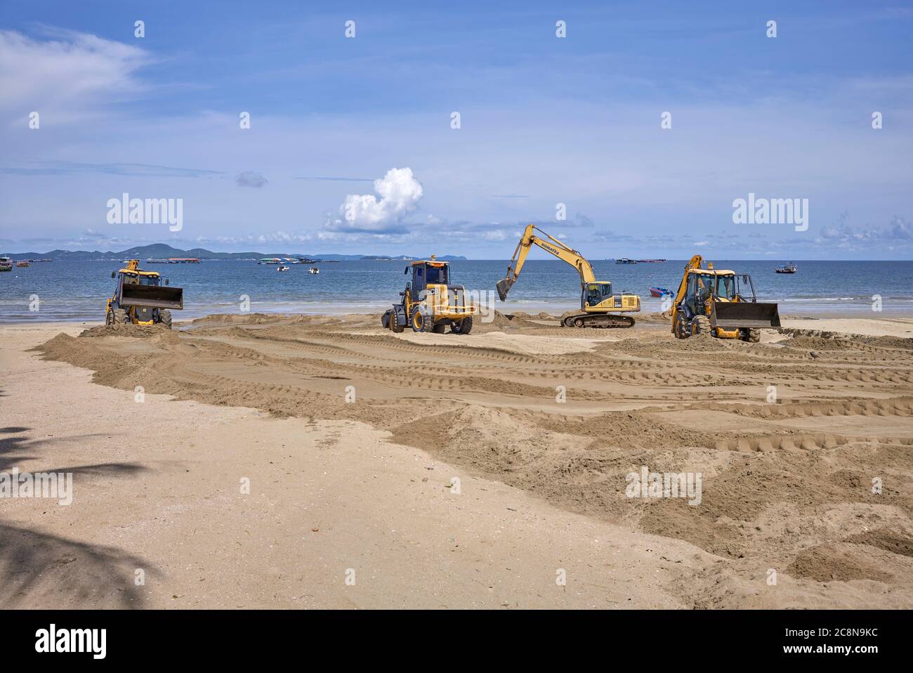 Backhoe beach. Digger working on the beach reclamation project at ...
