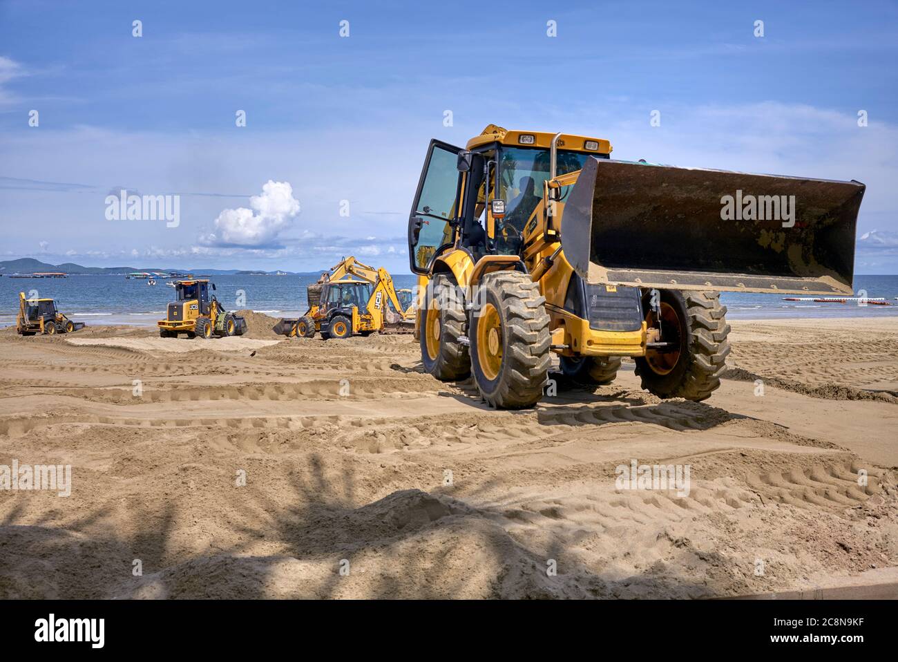 Backhoe beach. Digger working on the beach reclamation project at ...