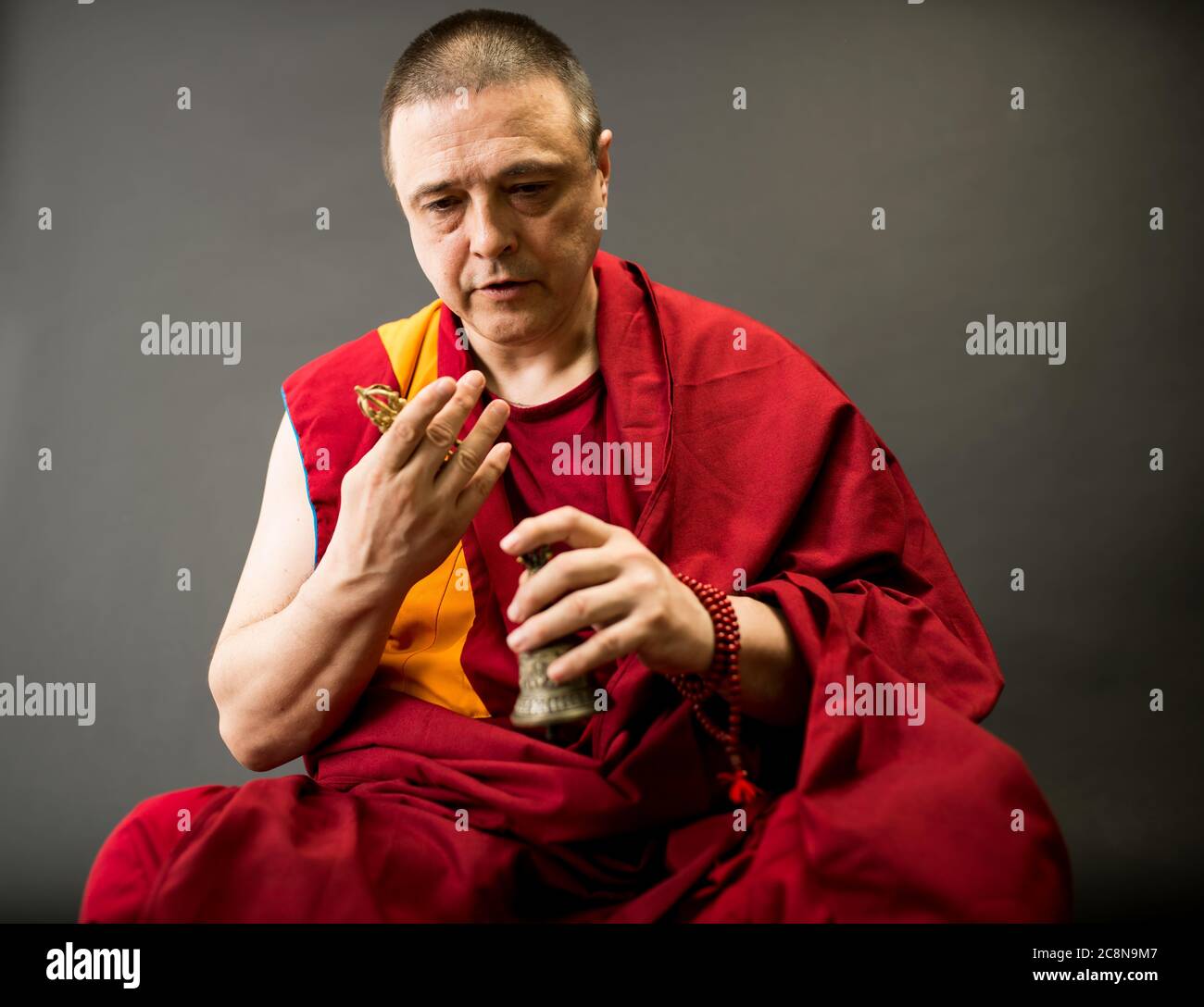 The monk holds a prayer drum in his hand. portrait of a Buddhist monk ...