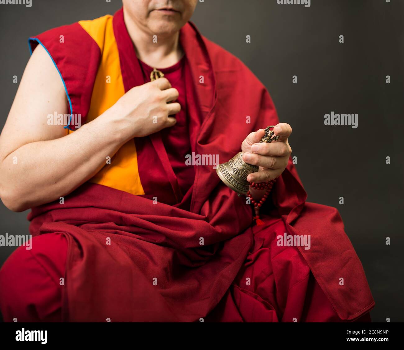 The monk holds a prayer drum in his hand. portrait of a Buddhist monk ...