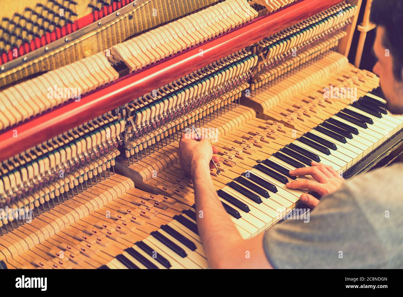 Piano tuning process. closeup of hand and tools of tuner working on ...