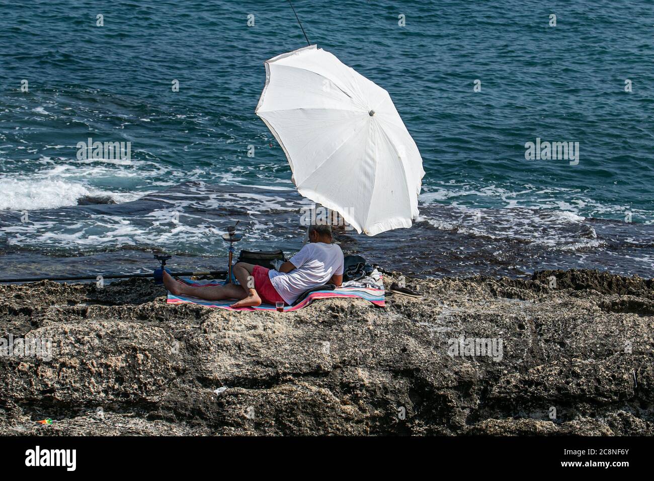 BEIRUT LEBANON. 26 July, 2020. People shelter under parasols on Beirut ...