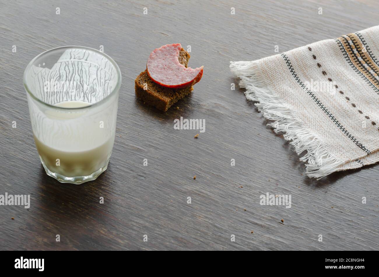 Glass half-empty glass of kefir and bitten sandwich on the table ...