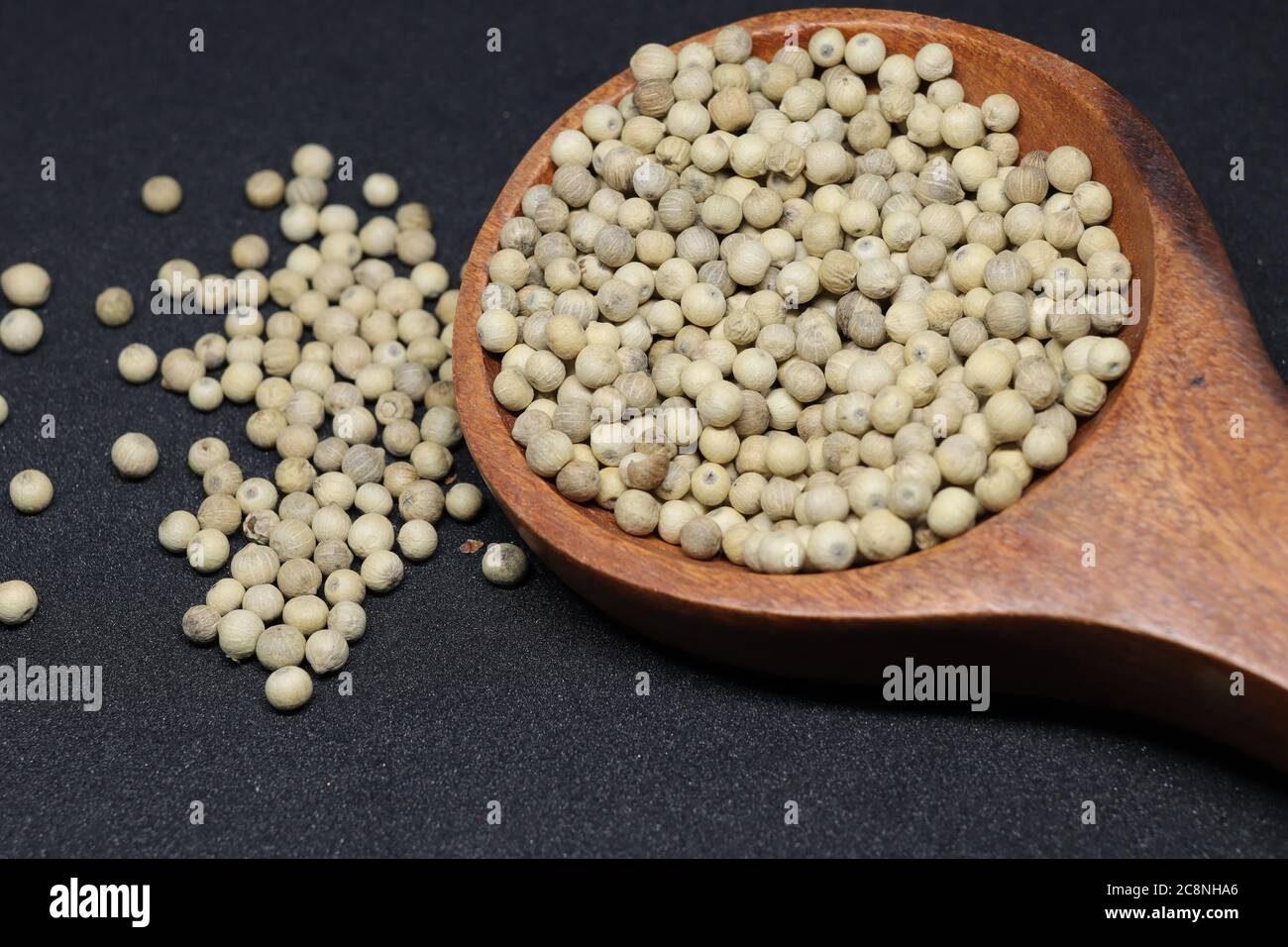 White pepper grains isolated on black background Stock Photo - Alamy