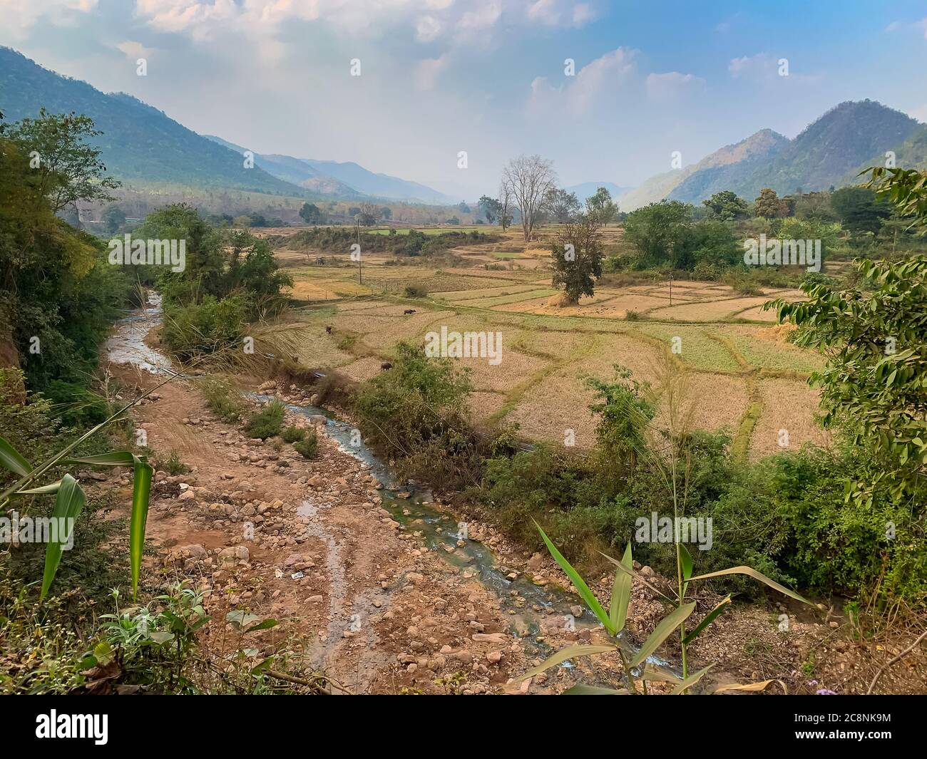 Nature landscape, green fields, flowing, stream mountain and cloud sky ...