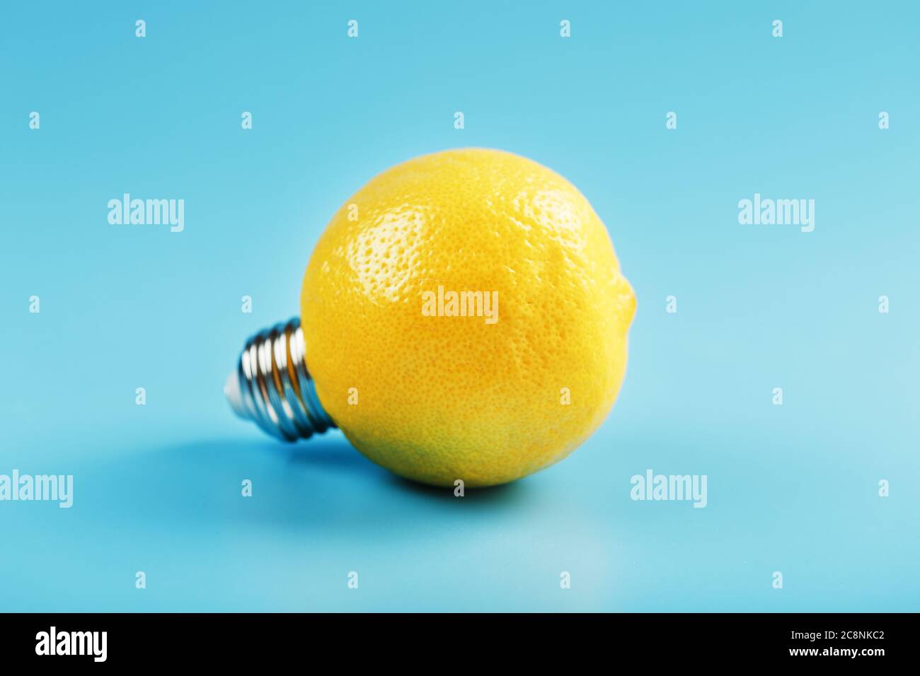 Lemon light bulb on a blue background. The fruit of a lemon with base ...