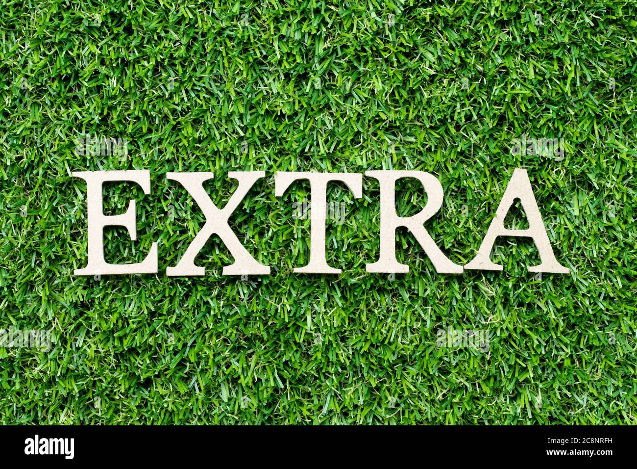 Wood alphabet letter in word extra on green grass background Stock ...