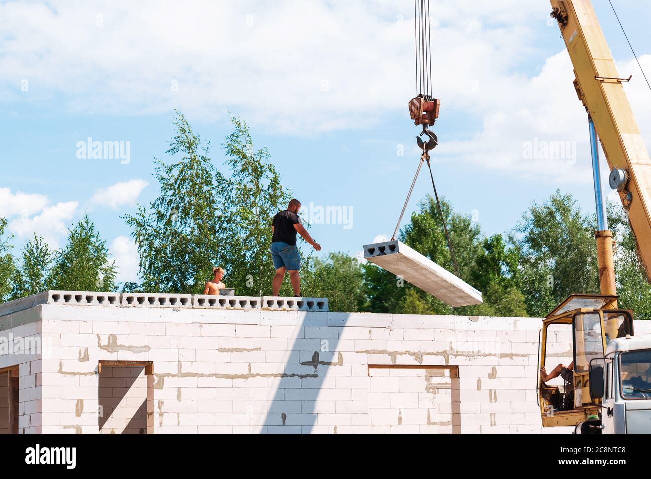 Builder worker installing concrete floor slab panel at building ...