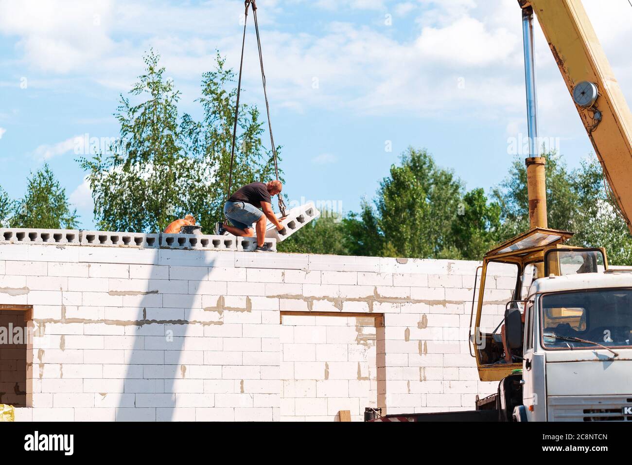 Builder worker installing concrete floor slab panel at building ...