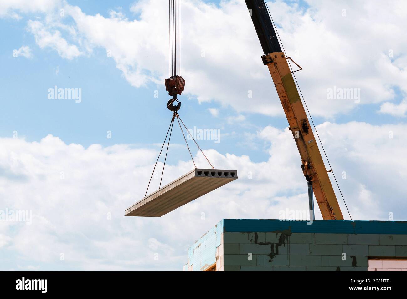 Builder worker installing concrete floor slab panel at building ...