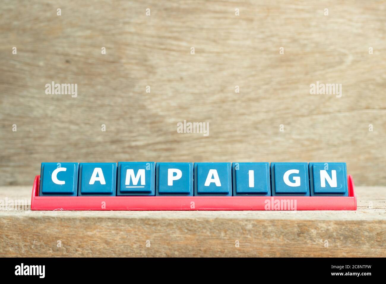 Tile letter on red rack in word campaign on wood background Stock Photo ...