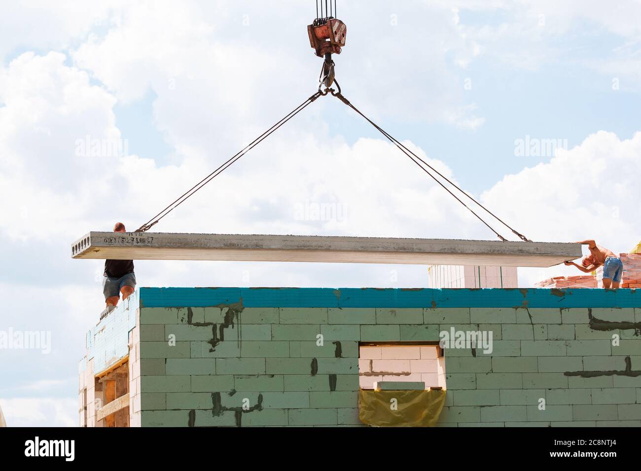 Builder worker installing concrete floor slab panel at building ...