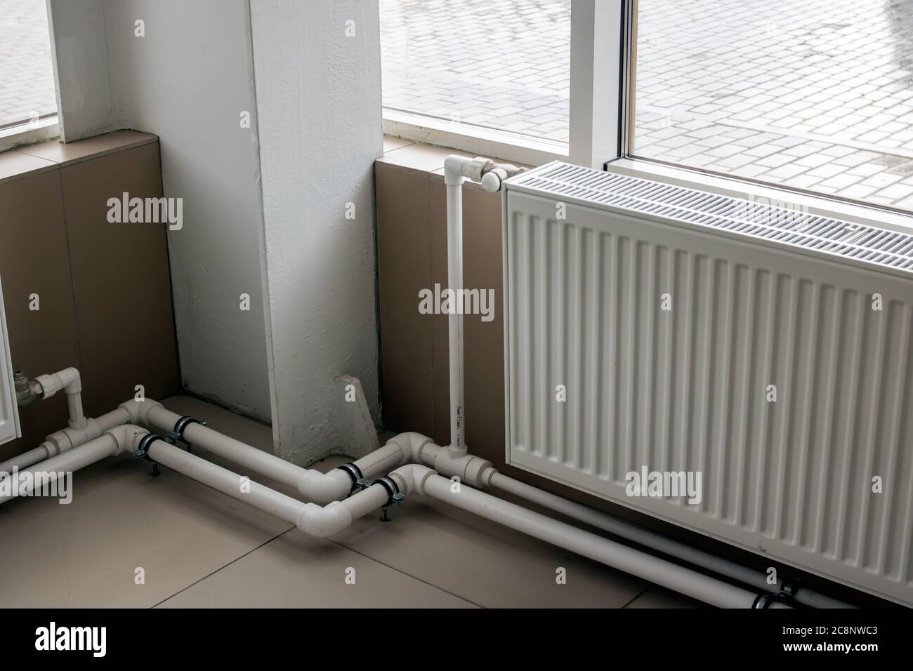 Pipes and radiator by the window close up Stock Photo - Alamy