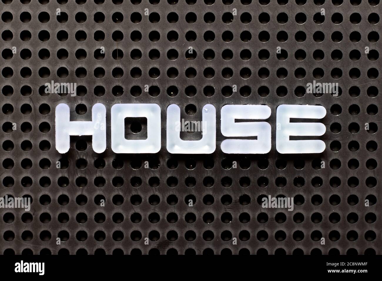 White color alphabet with word house on black pegboard background Stock ...