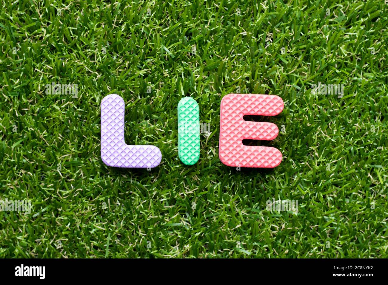 Toy foam letter in word lie on green grass background Stock Photo - Alamy