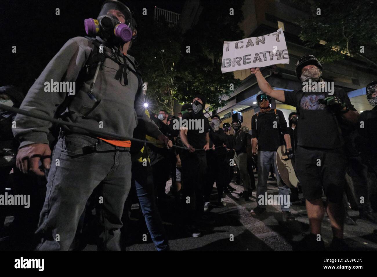 Portland, USA. 26th July, 2020. Protesters prepare to pull on a rope ...
