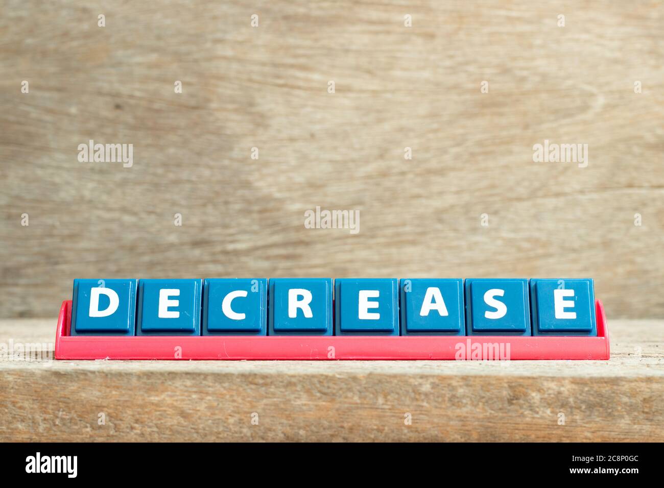 Tile letter on red rack in word decrease on wood background Stock Photo ...