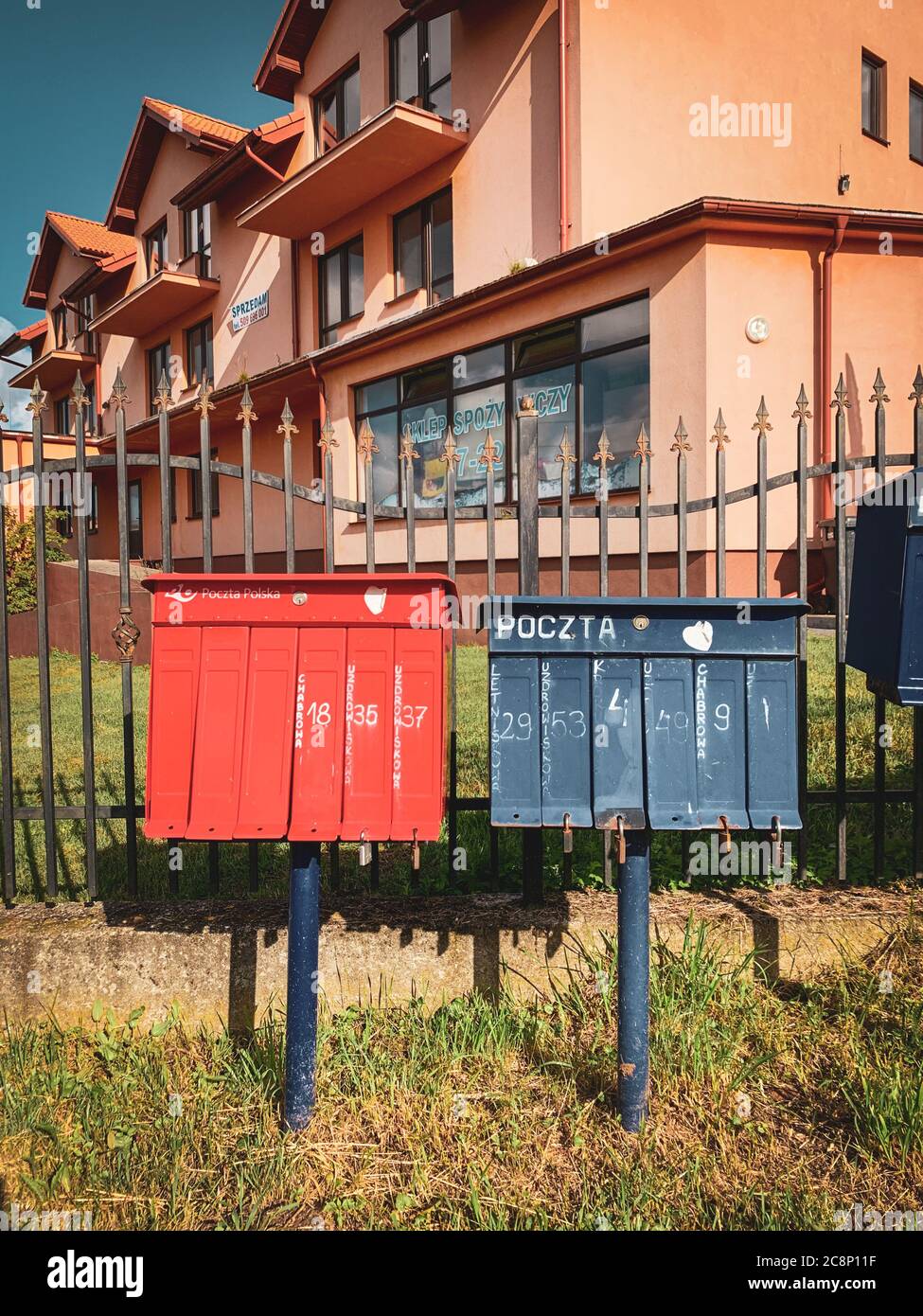 red and blue mailboxes standing on a street in a village in Poland ...