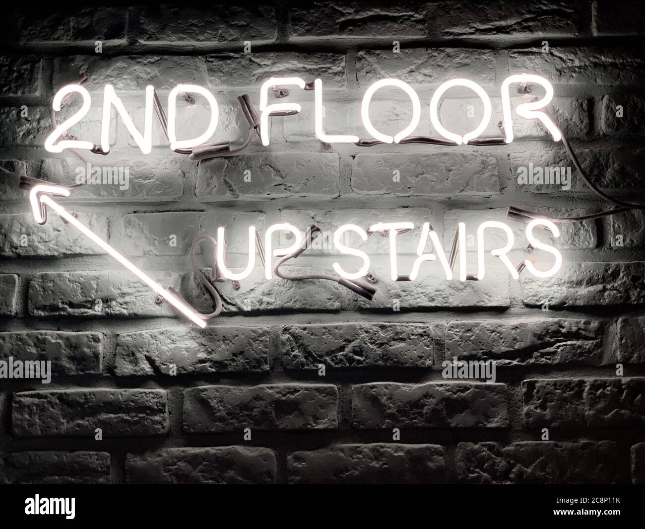 there's a neon sign on the wall that says "2nd Floor upstairs Stock ...