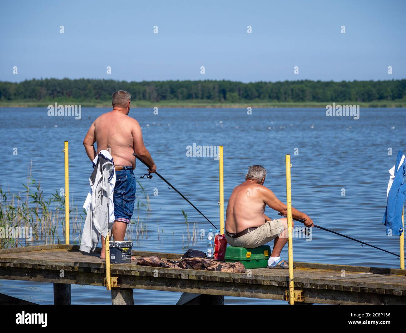 two fishermen stand on a landing stage and fish Stock Photo - Alamy