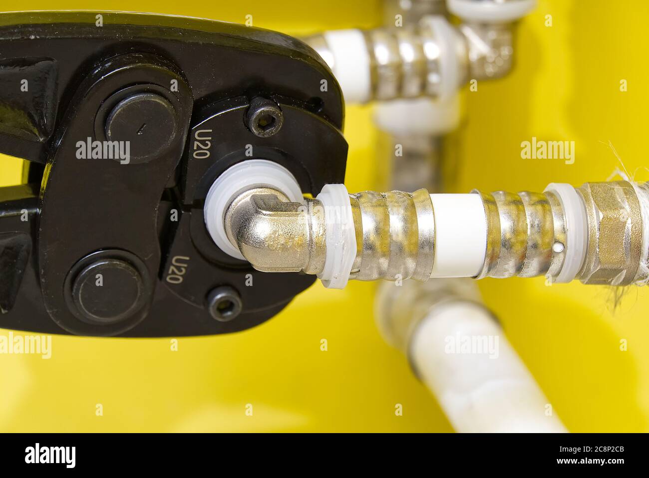 Worker connecting alupex pipes with a tap. Hand press for water pipes ...