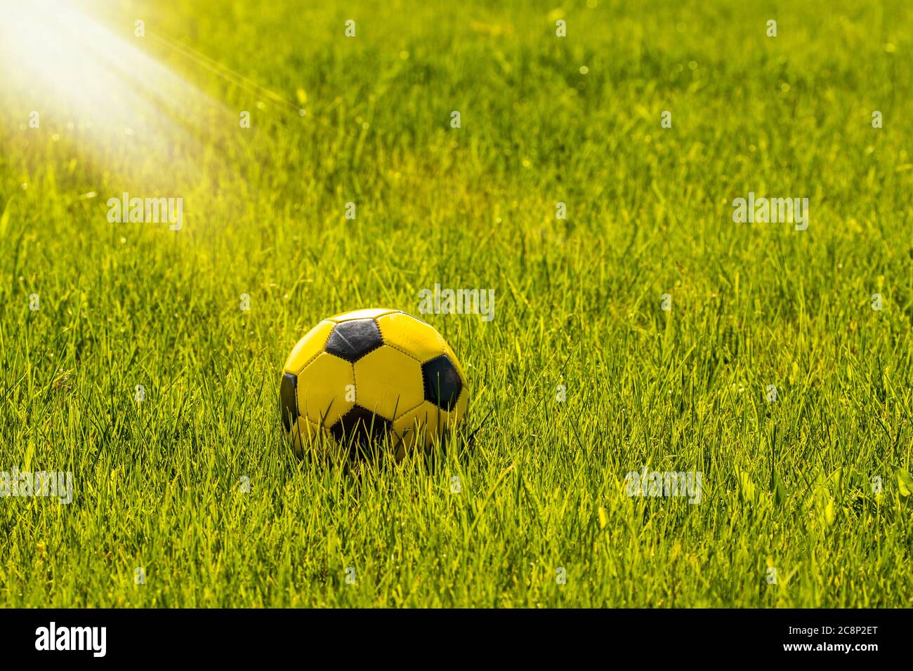 Yellow soccer ball or football in stadium with sunlight Stock Photo - Alamy