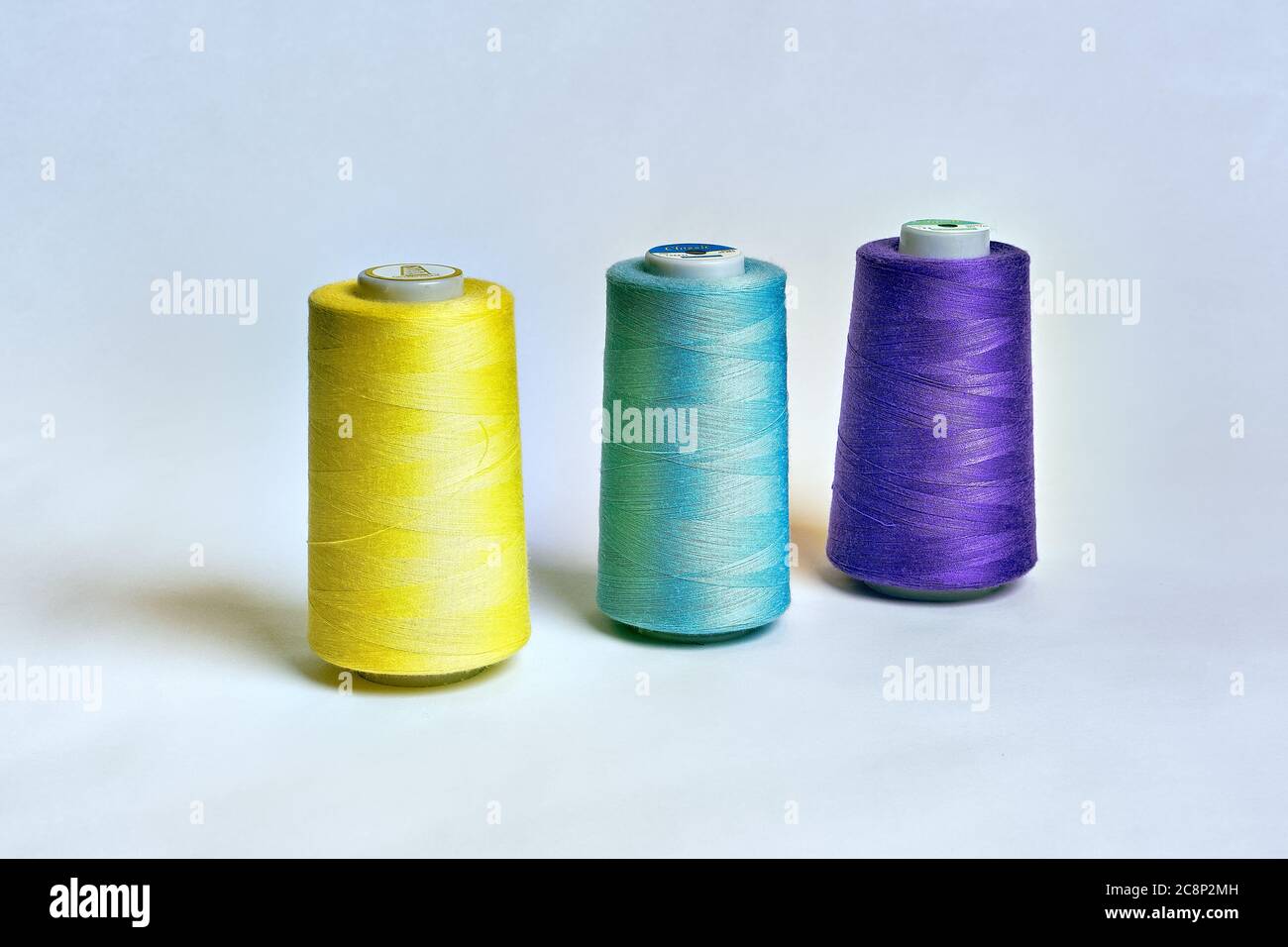 Sewing thread rolls in different colors on white background Stock Photo ...