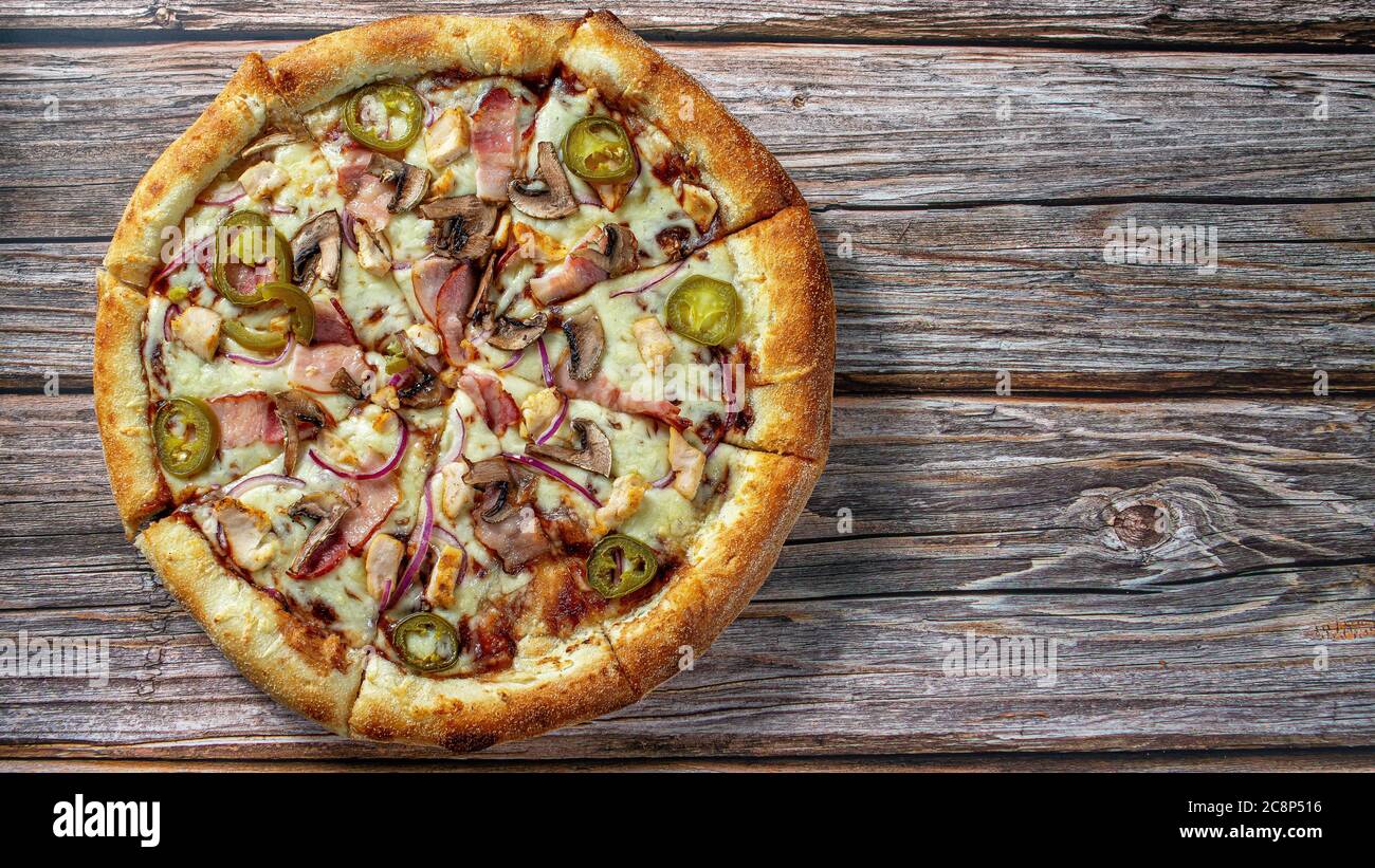 Pizza with chicken, ham and jalapeno pepper Stock Photo - Alamy