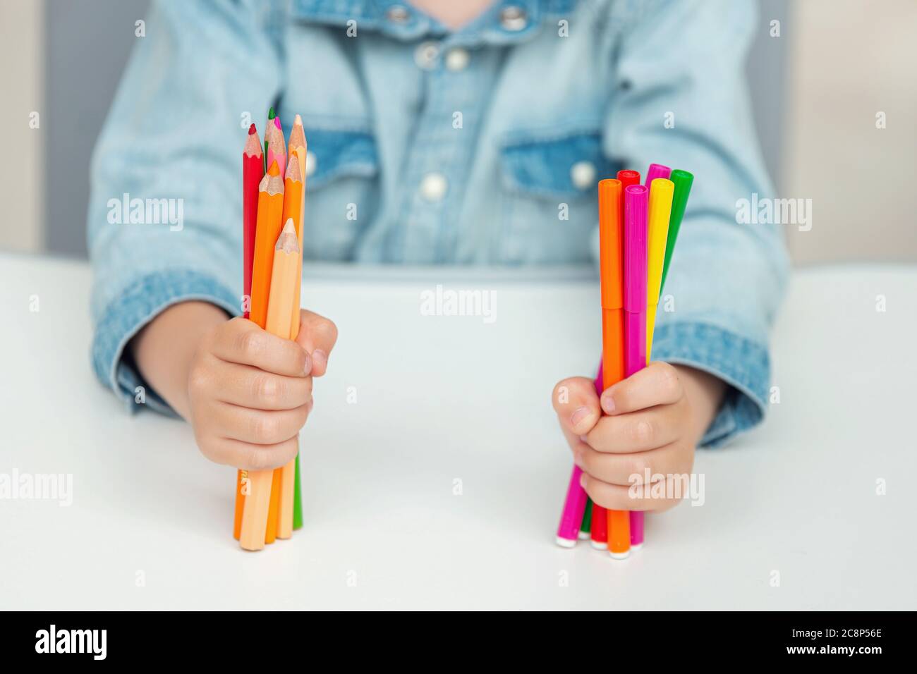 A child holds a felt pens and pencils. School concept Stock Photo - Alamy
