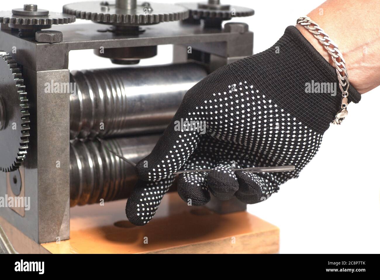 Jeweler at work, process rolling of a silver wire crafting in a ...