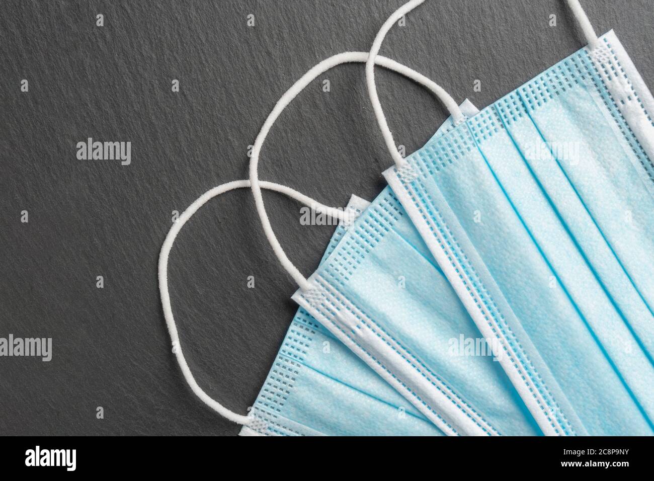 Medical surgical masks on gray stone background. Blue disposable safety ...