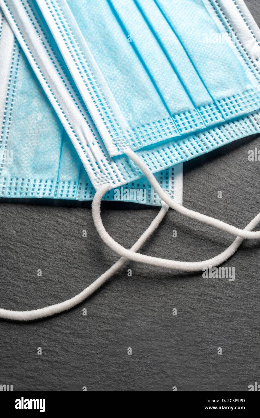 Close-up of disposable medical protective masks on gray dark stone ...