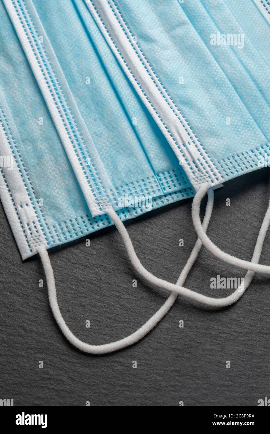 Medical surgical masks on gray stone background. Blue disposable safety ...