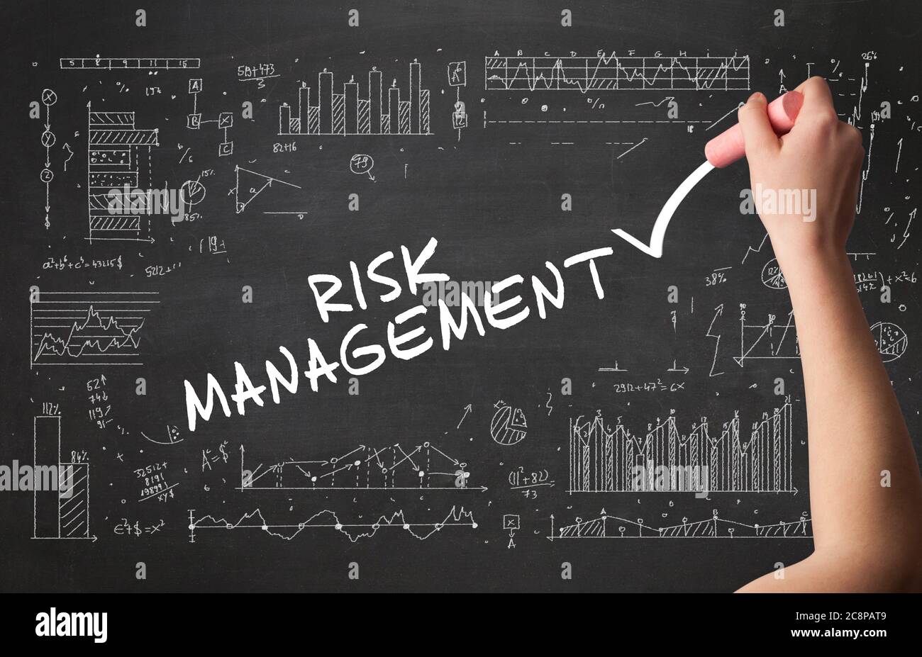 Hand drawing RISK MANAGEMENT inscription with white chalk on blackboard ...
