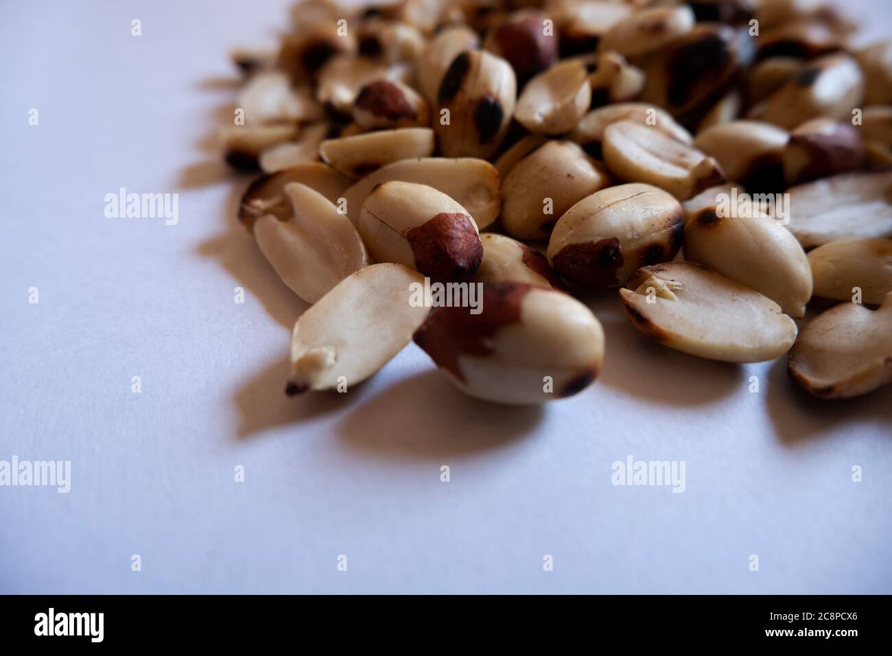 a fried groundnuts gathering on white surface Stock Photo - Alamy