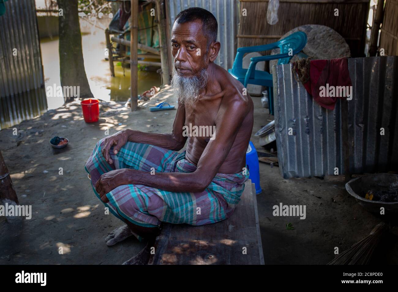 A landless farmer, victim of climate change, takes shelter on an ...