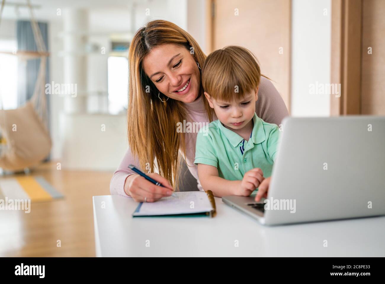 Mother working at home-office with child on her lap Stock Photo - Alamy