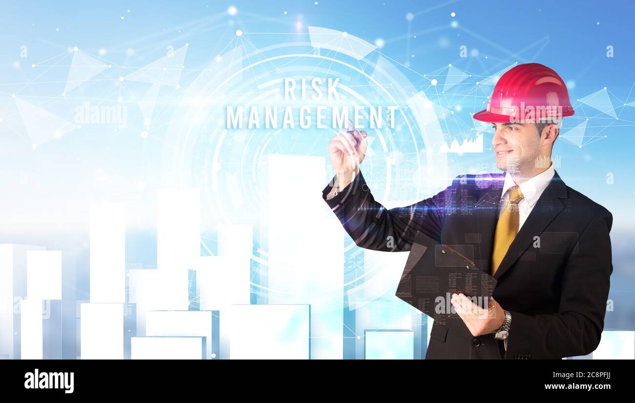 Handsome businessman with helmet drawing RISK MANAGEMENT inscription ...