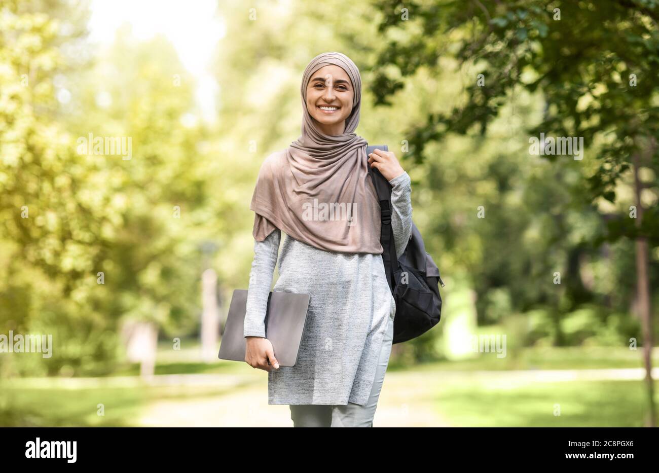 Successful arab woman freelancer walking by park Stock Photo - Alamy