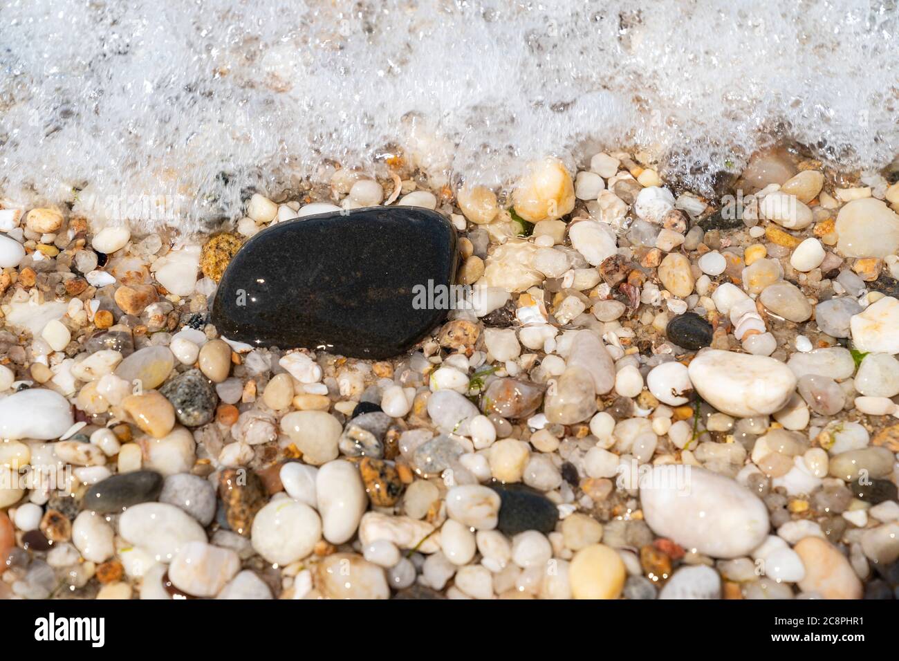 Wet marble and granite pebbles on the ocean beach Stock Photo - Alamy