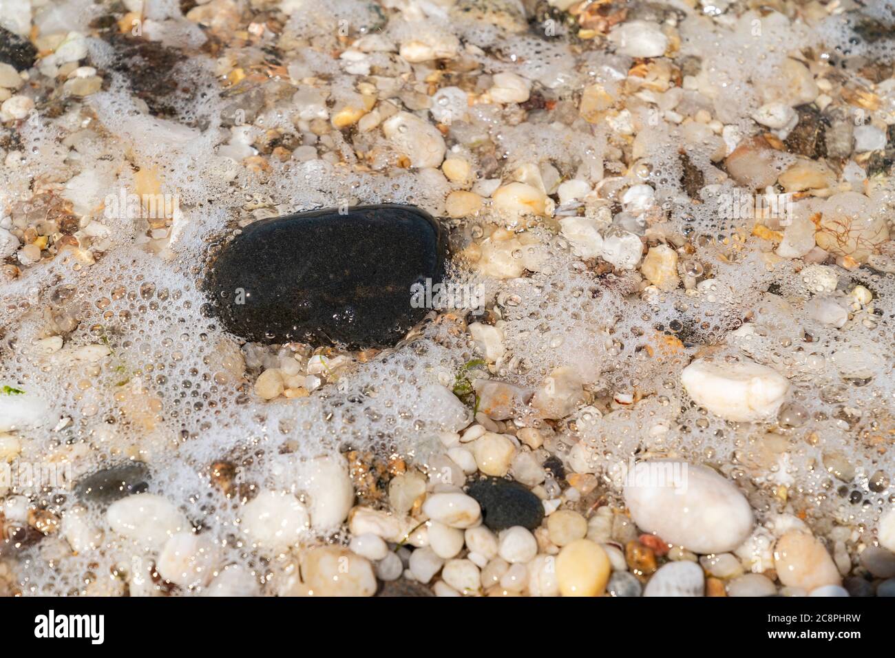 Wet marble and granite pebbles on the ocean beach Stock Photo - Alamy