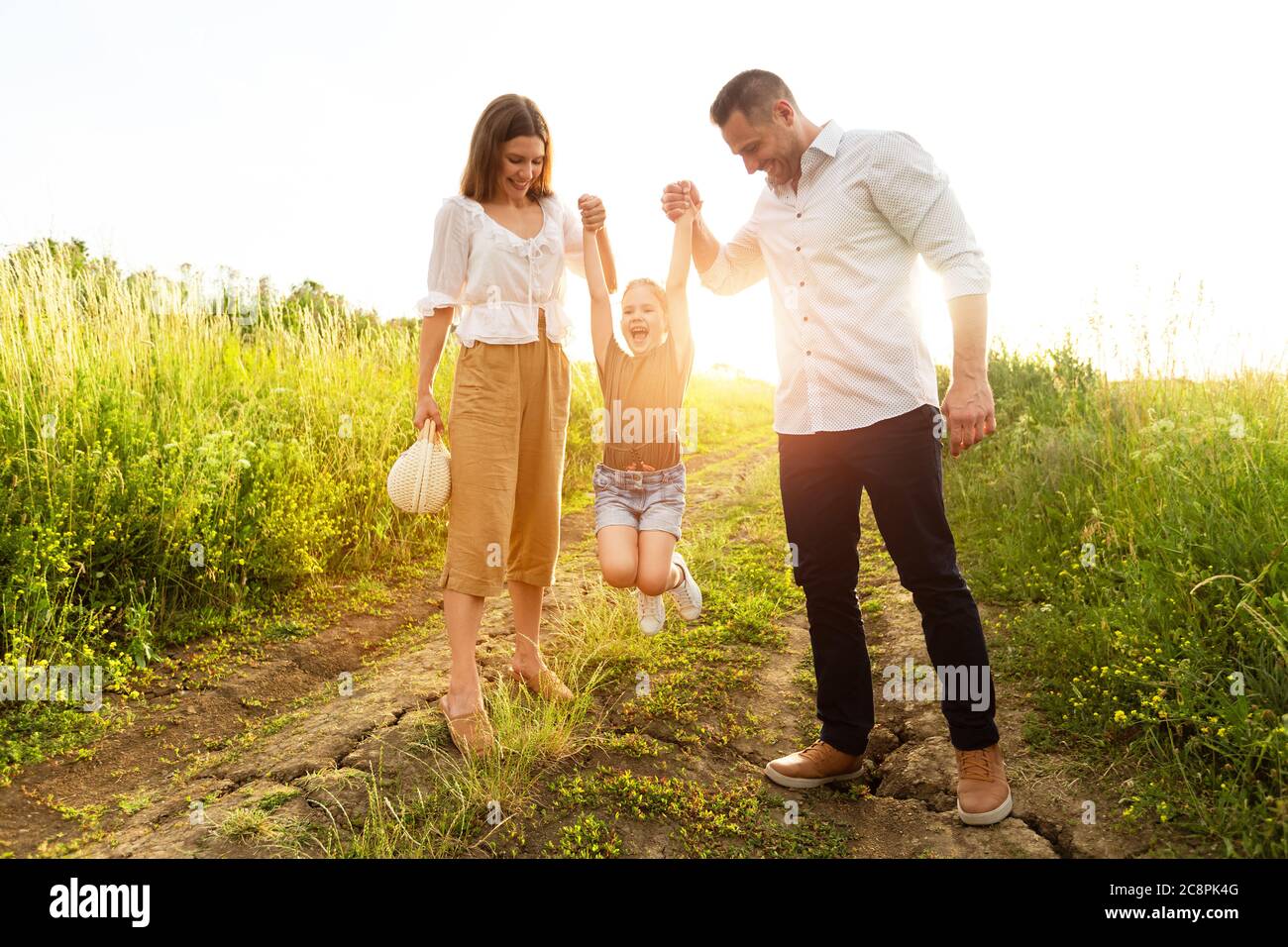 Happy parents and kid walking together in summer Stock Photo - Alamy