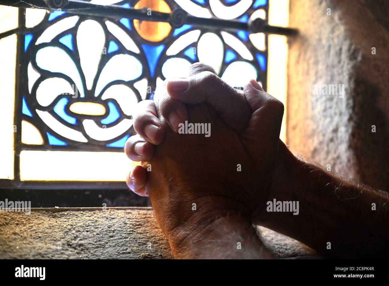 A pray behind a stained glass window Stock Photo - Alamy