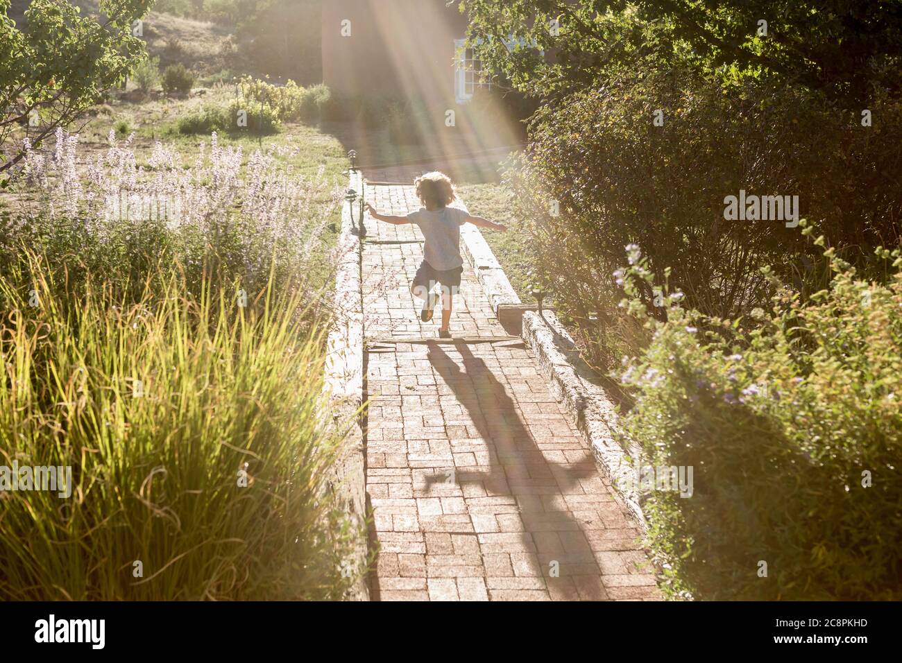 4 year old boy running on brick path Stock Photo - Alamy