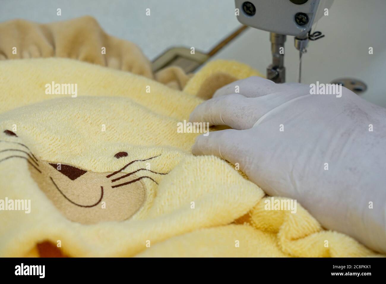 hand in a glove near the sewing machine Stock Photo - Alamy