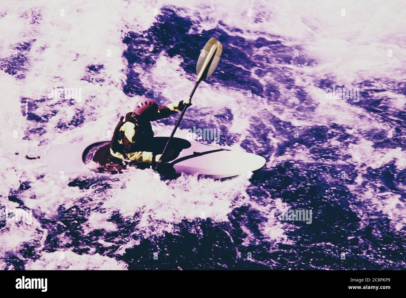 Color infrared image of white kayaker paddling river rapids on a fast ...