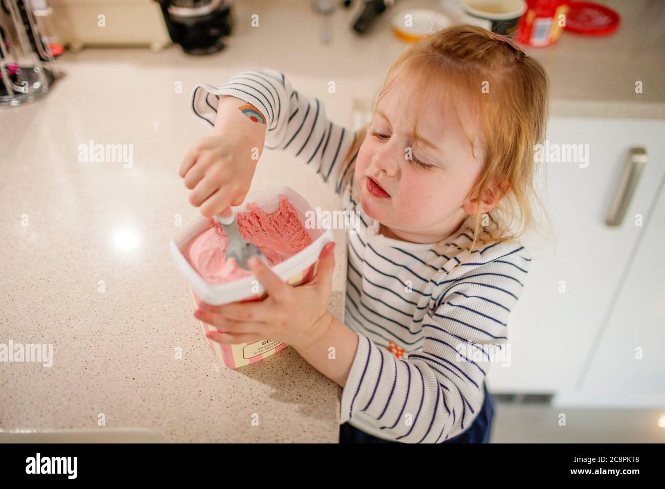 Young girl helping herself to ice cream Stock Photo - Alamy