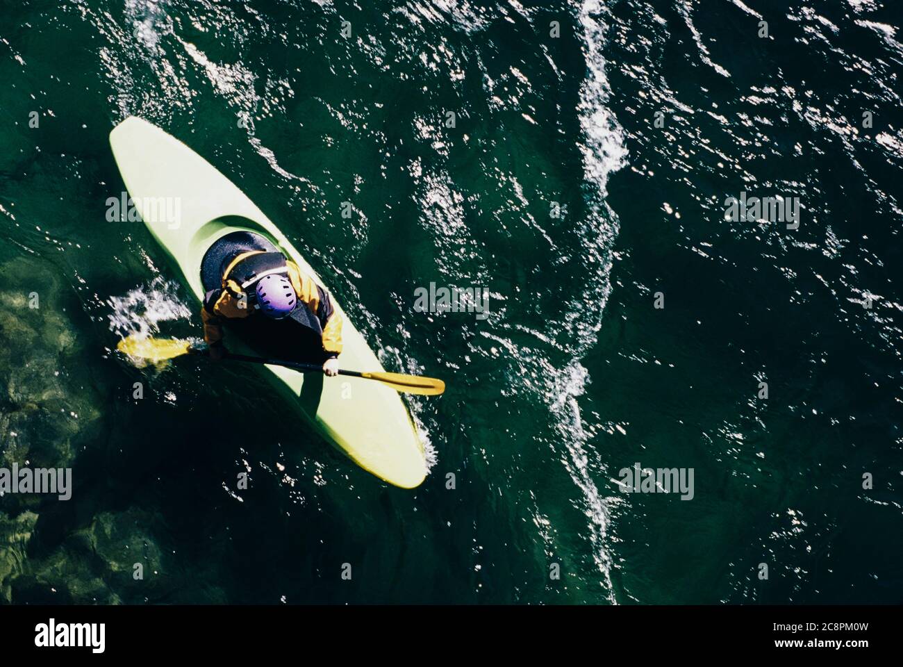 Overhead view of whitewater kayaker paddling rapids on a fast flowing ...