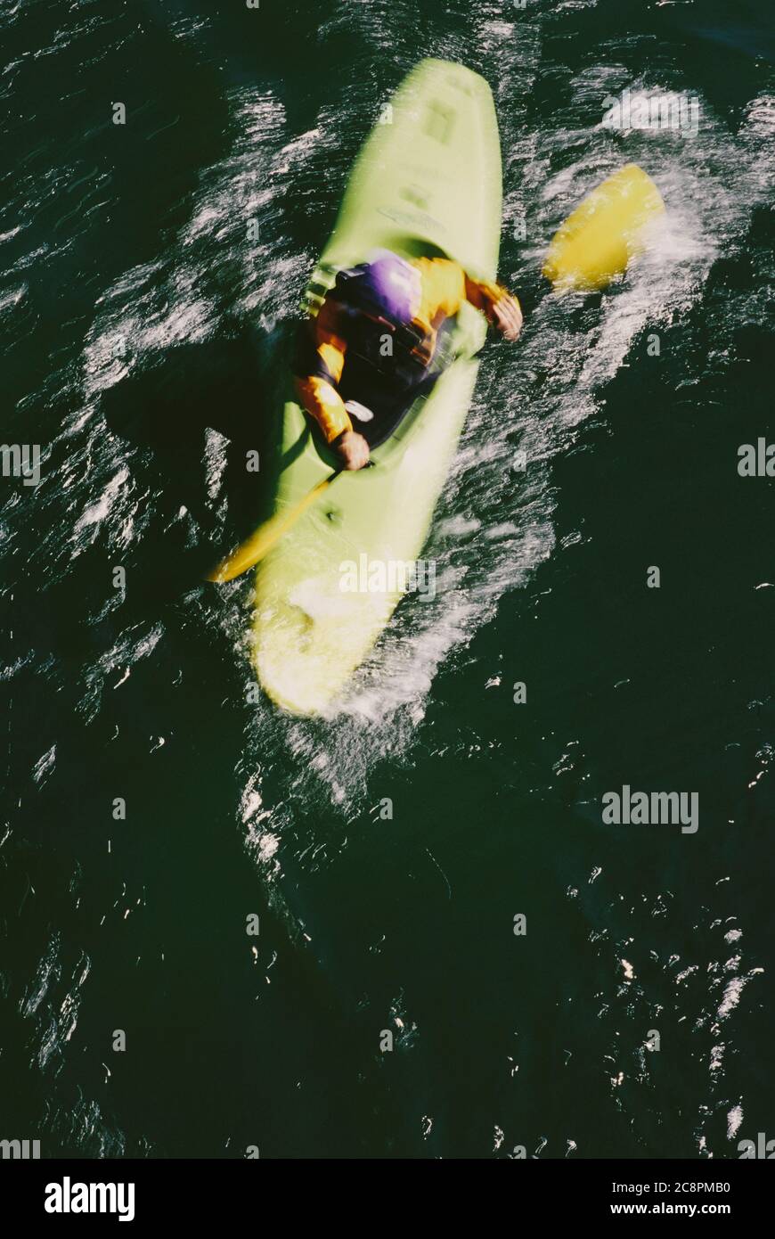 Overhead view of whitewater kayaker paddling rapids on a fast flowing ...