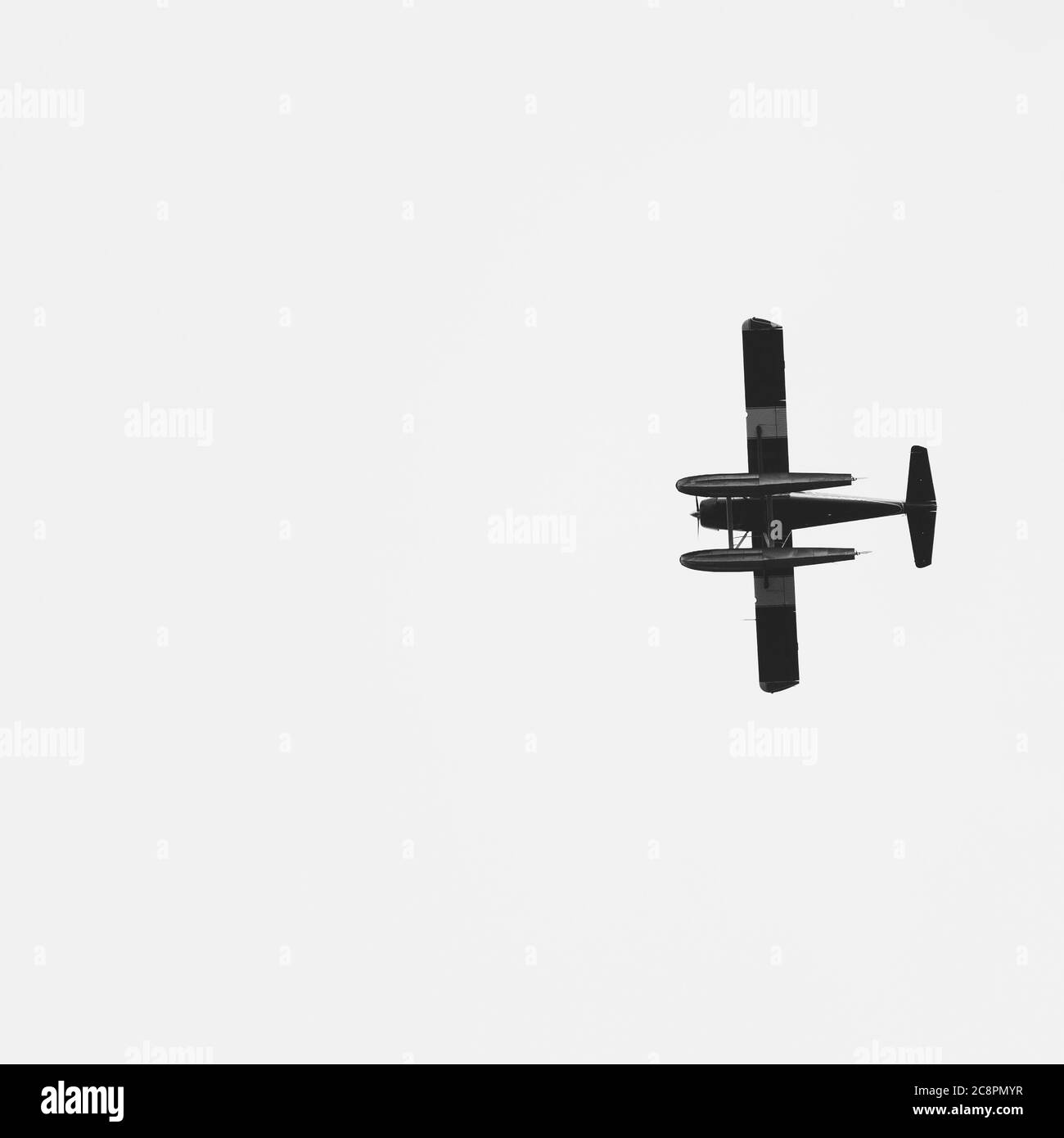 Single engine bush plane flying across open sky (plane is a DeHavilland ...